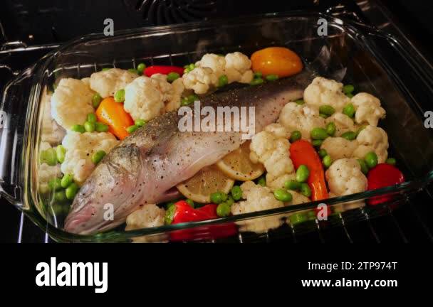 process of cooking sea bass fish with vegetables in the oven. Time ...