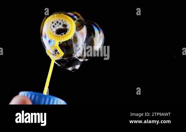 Hand Holding Many Rainbow Soap Bubble on a Yellow Ring, Black ...