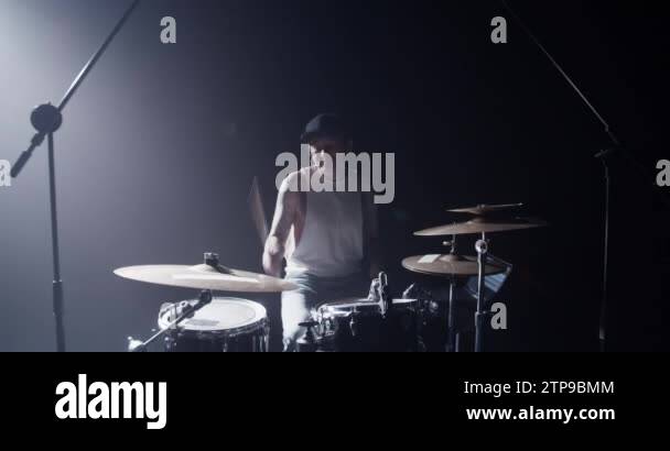 Full body of talented young male drummer in casual clothes and cap ...