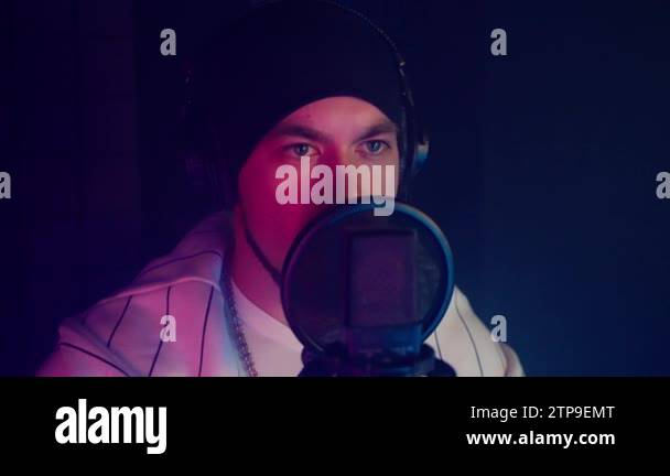 attractive talented man is singing song to microphone in recording ...