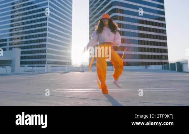 Joyful multi racial girl in sports outfit wearing trendy bright orange ...