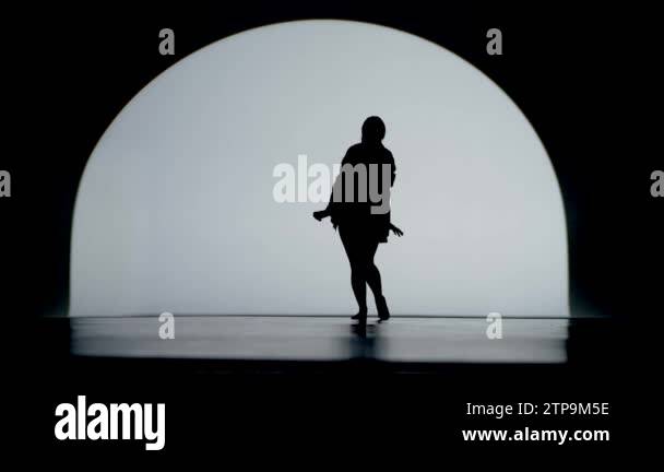 Contrasting silhouette of a young woman performing emotional ...