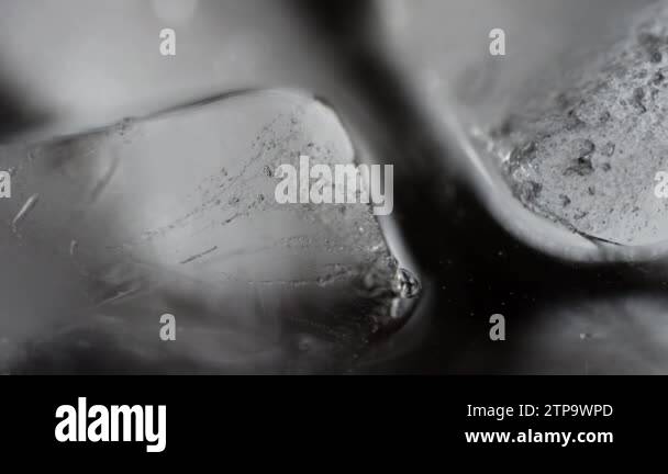 Close-up of a bubble passing through an ice cube: A fluid dynamics. The ...