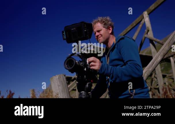 A low-angle shot frames a dedicated filmmaker skillfully operating a ...