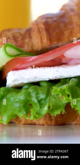 croissant with egg, meat, tomatoes and Brie cheese breakfast lunch on a ...