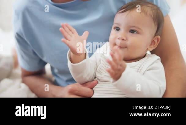 Young infant, clapping and bed with parents, care or learning with ...