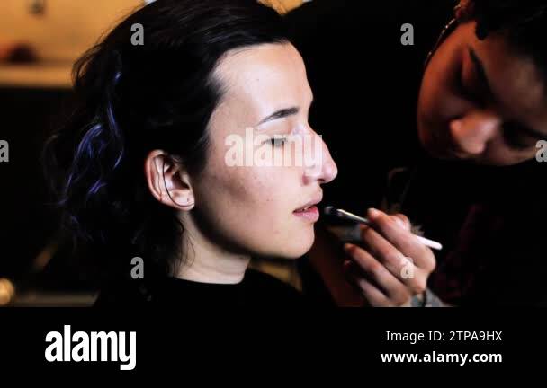 young woman being made up by professional makeup artist in a dressing ...