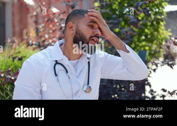 Upset male doctor wearing white lab coat and stethoscope staying ...