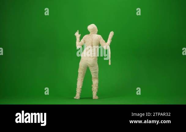 Scary mummy looks around, searches for a victim and scares with raised ...