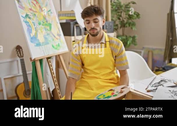 Concentrated young arab man, a passionate artist, ensnared in a moment ...