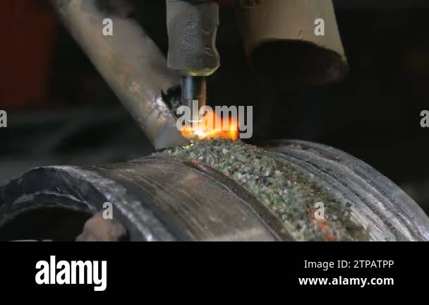 Close up of welding robots apply overlay weld protection on the pipe ...
