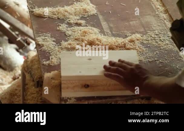 Close up of a carpenter working in a simple wood workshop. The workshop ...