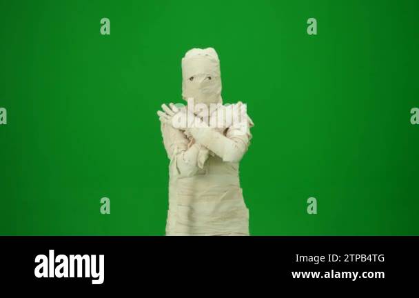 Scary mummy wrapped in bandages dancing the Macarena dance. Green ...