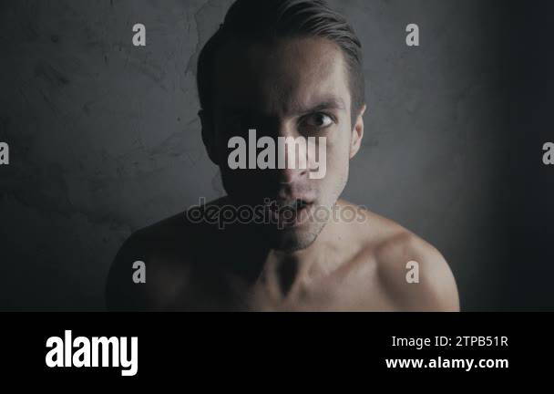 Angry and dangerous man in a dark room. Emotion of the evil man. Mouth ...