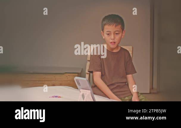 .The boy sat and ate delicious popcorn.Boy staring at cell phone while ...