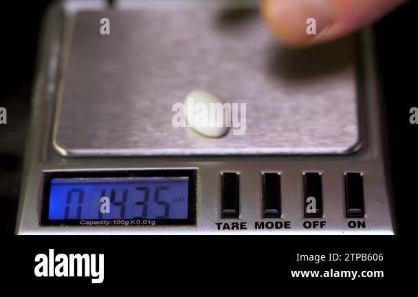 Pharmacist, a laboratory worker in sterile rubber gloves, weighs the ...