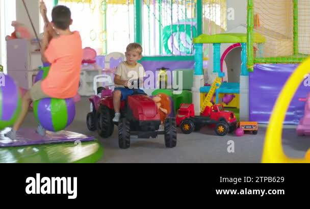Boy driving a pedal car, child having fun riding a car in an amusement ...