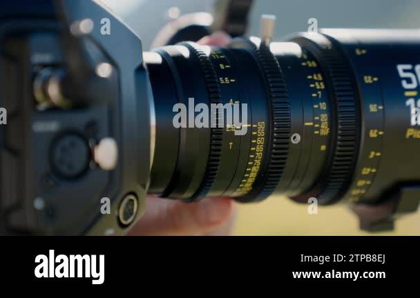 A close-up shot of a hand delicately adjusting a cinematic lens, fine ...