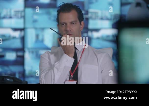 4K Security team watching CCTV screens in control room, officer talking ...