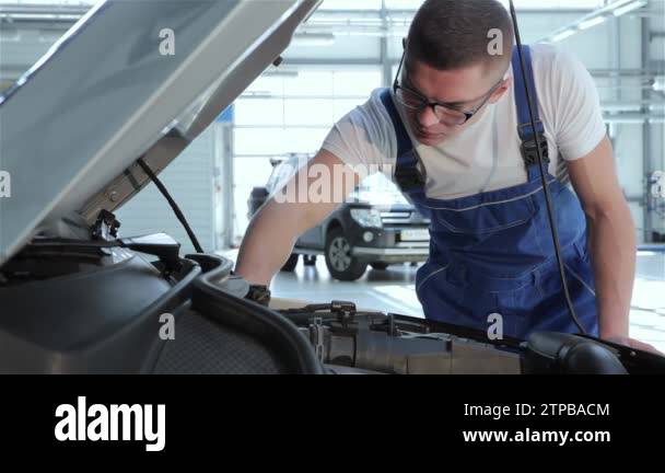 Blond mechanic checking up serviceabillity of the car. Young caucasian ...