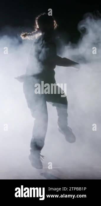 Dancer performing hip hop dance in slow motion with light and smoke ...