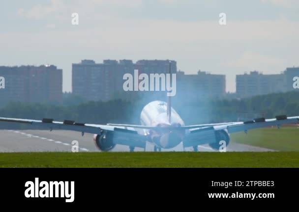 Cinematic footage of a passenger plane touching the runway and braking ...