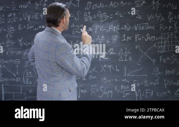 4K Portrait smiling academic man studying math formulas on blackboard ...