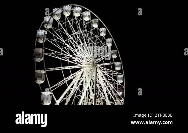 Illuminated white color colour ferris wheel spinning clockwise against ...