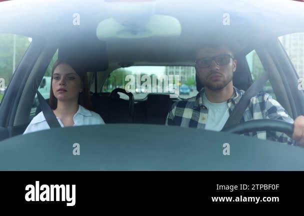 Stunned couple in car looking with shocked face expression on the road ...