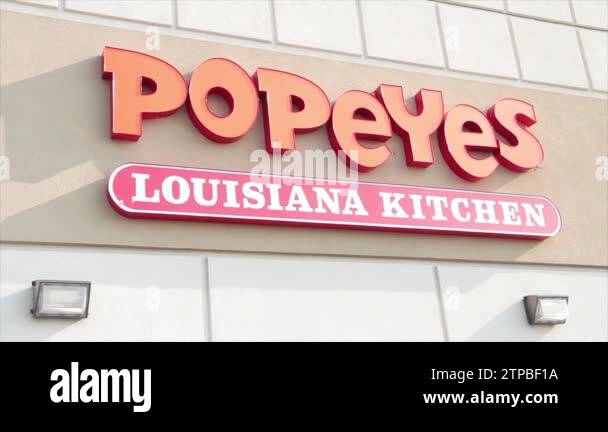 popeyes louisiana kitchen orange white sign logo on wall on back of ...