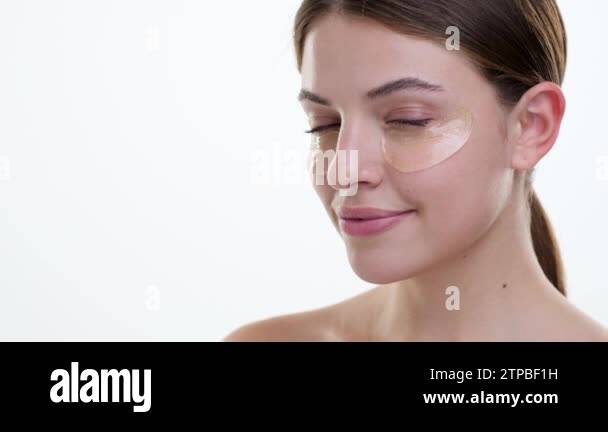 Woman places eye patches with precision, enhancing under eye area with ...