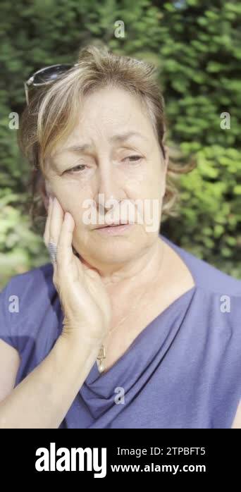 Sunny Serenity - Middle-Aged Woman Relishing Day on Park Bench, Soaking ...