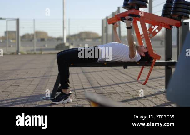 Fit and Muscular Young Man Focuses on his Arm Muscle Workout Outside ...