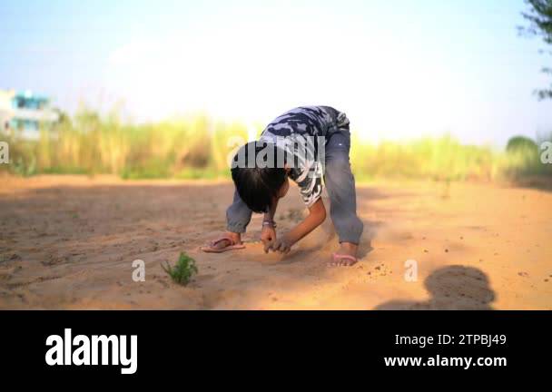 The Dirty hands of a little boy child are digging in the dry mud ...