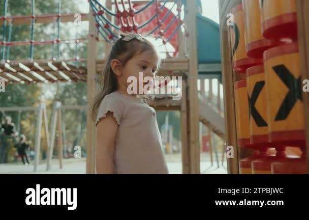 Little girl in casual clothes playing on kids playground. Cute little ...