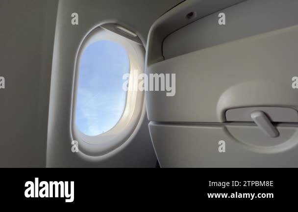 Airplane window during flight. Passenger POV staring at tray table ...