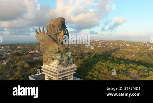 Drone Aerial view 4k Statue of Vishnu in Garuda Wisnu Kencana Cultural Park at sunrise. Bali's ...