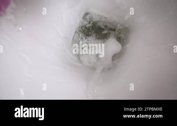 Flushing toilet in slow motion, close-up. Inside view of spinning water ...