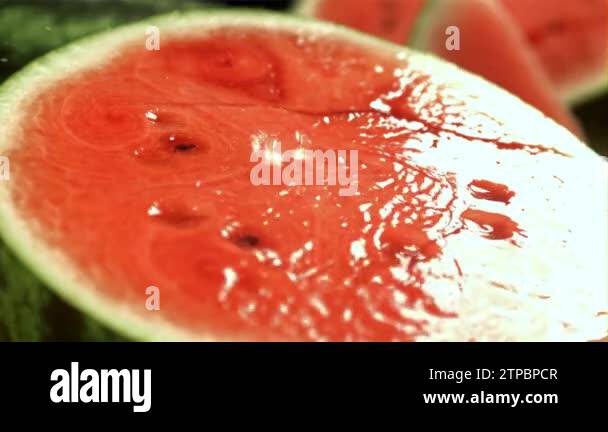 Drops of water fall on the cut of a watermelon. Filmed on a high-speed ...