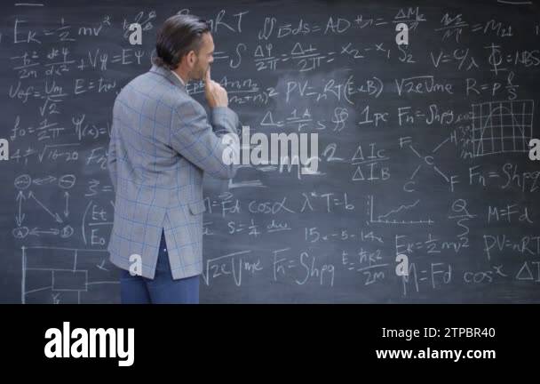 4K Portrait smiling academic man studying math formulas on blackboard ...