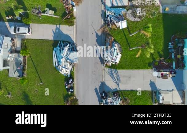 Heaps of debris rubbish on street side near severely damaged by hurricane Ian houses in Florida ...