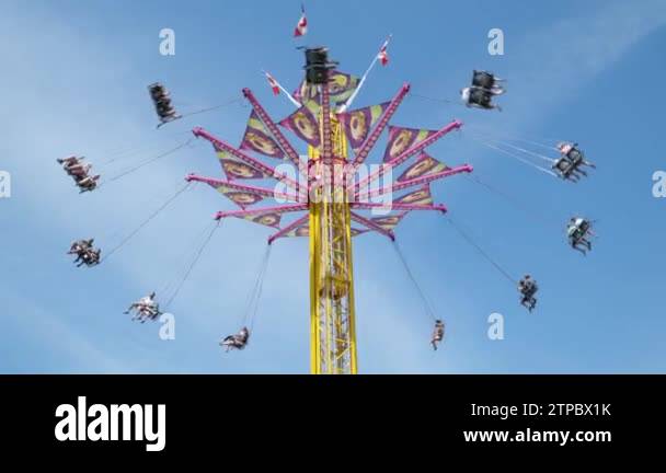 People riding on spinning swing carousel in amusement park Swing rides ...
