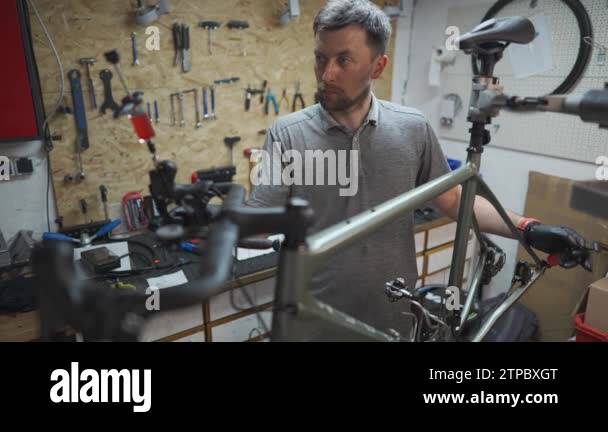 Bicycle mechanic holding syringe with brake fluid during brake bleeding process. Cycle repairman ...