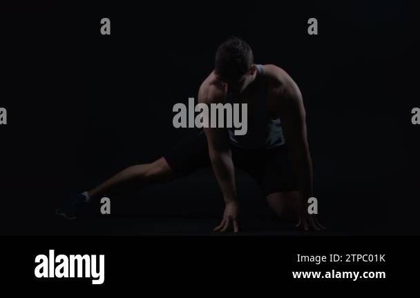 4K Fit young man with muscular physique doing stretches to improve ...