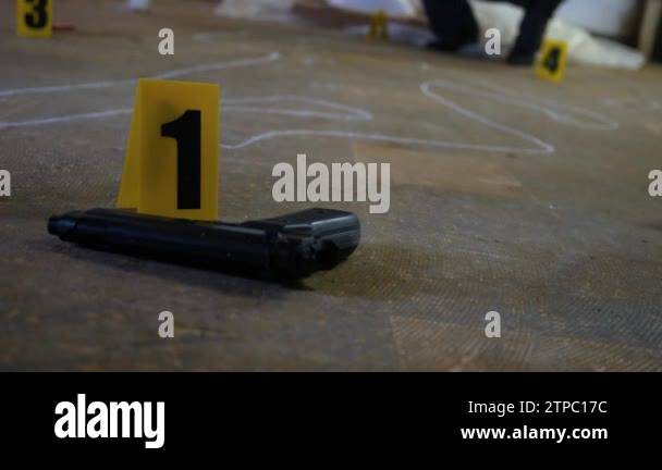 Cinematic camera move past 9mm handgun with evidence marker at active ...