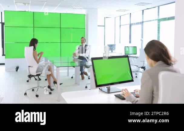 4K Business team in modern office green screen on video wall and ...