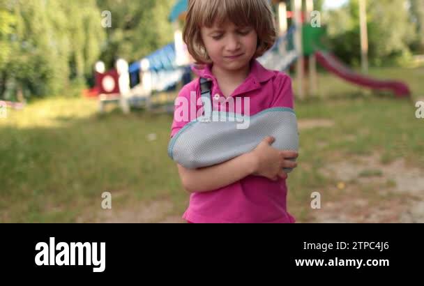 Sad child outdoors with a broken limb small, injured boy. The child has ...