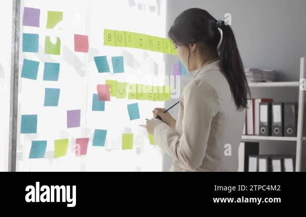 Young entrepreneur, Asian accountant holding a post-it note on glass ...