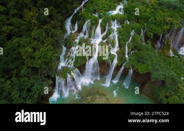 Powerful waterfall flows into a lake with azure clear water. Plitvice ...