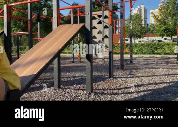 Young multiracial woman in an open-air gym at a public park, powering ...
